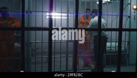 Warden brings guilty prisoner in jail cell and takes off handcuffs ...