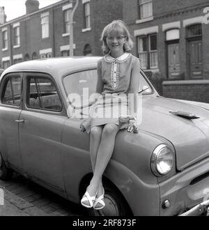 1959, historical, outside in the street on a pavement, a young girl ...