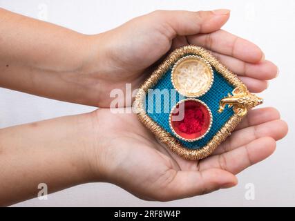 Hand holding beautiful small pooja thali having God Ganesh face, red ...