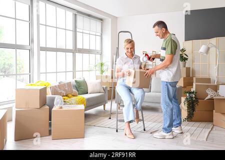 Mature couple taping box in room on moving day Stock Photo - Alamy
