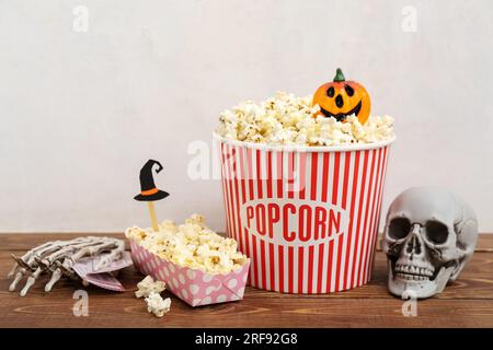 Composition with tasty popcorn, skull, skeleton hands and cinema ...