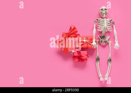 Composition with beautiful gift boxes, skeleton hand and bats made of ...