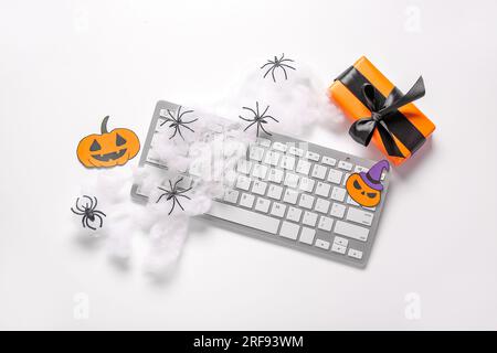 Modern computer keyboard, web and spiders for Halloween on white ...
