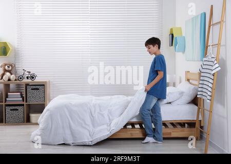 Boy changing bed linens in children room Stock Photo - Alamy