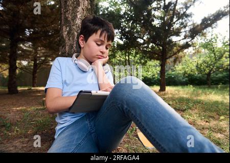 Adorable hispanic boy student writing on notebook holding molecules at ...