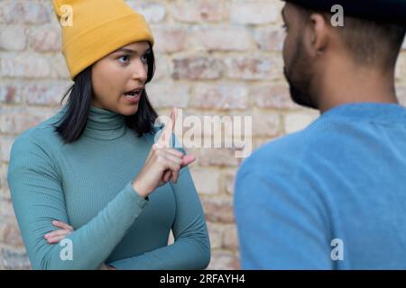 Woman gesturing and talking with hipster boyfriend sitting on window ...