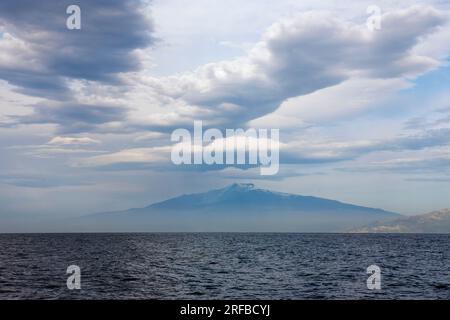 Lenticular cloud over Mount Etna in early morning from seaward at the ...