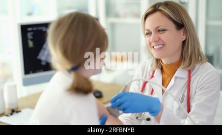 Medical diagnostician conducts ultrasound examination of back of little ...