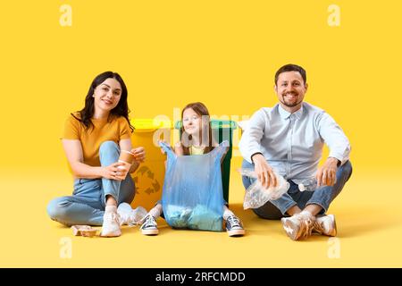 Family with garbage bag and recycle bins on yellow background Stock ...