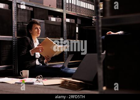 Overworked woman private detective analyzing investigation report and ...