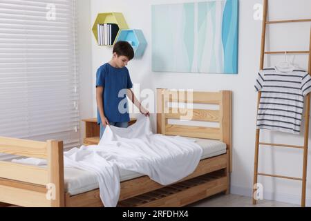 Boy changing bed linens in children room Stock Photo - Alamy