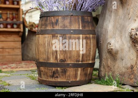 Traditional wooden barrel and decorative branches outdoors, closeup ...