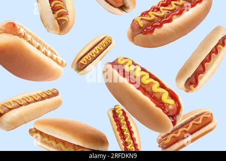 Many tasty hot dogs falling on pale brown background Stock Photo - Alamy
