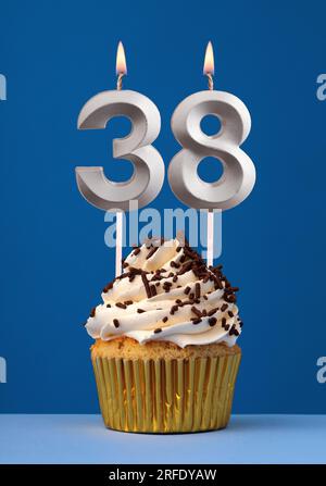 Birthday number 38 - Candle lit on blue background Stock Photo - Alamy