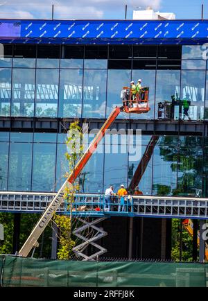 Workers are installing glass panels on wooden frames at construction ...