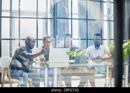 ehind the glass view of executives discussing project in modern office ...