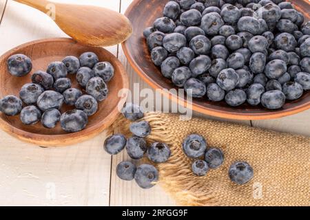 ripe blueberries in a clay plate on a brown wooden background. place ...