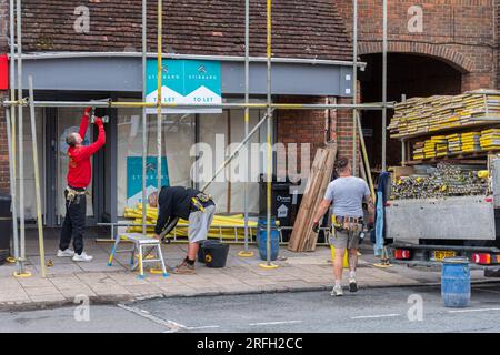 Scaffolders at work, setting up scaffolding around a building, England ...