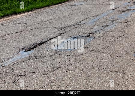 poorly made and dangerous for traffic paved road with holes, paved road ...
