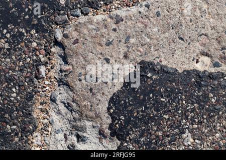 a bad road with poorly repaired potholes and pits, a road of poor ...