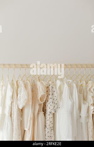 delicate rack of neutral dresses on gold hangers Stock Photo - Alamy