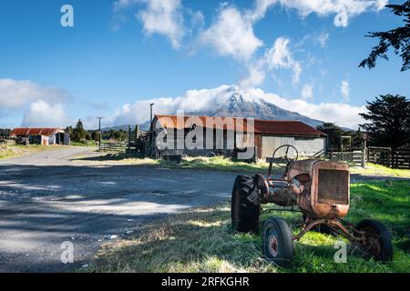 Tractor, farm buildings and Mount Taranaki, North Island, New Zealand ...