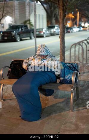Homeless man tries to keep warm while sleeping on a New York city ...