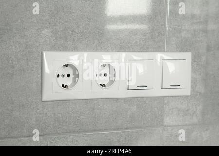 Light switches and power sockets on white wall indoors Stock Photo - Alamy
