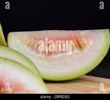 cut small unripe watermelon on a board, cut into pieces unripe ...