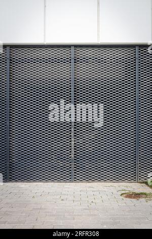 Iron grid wall and a sidewalk. Architecture detail background Stock ...