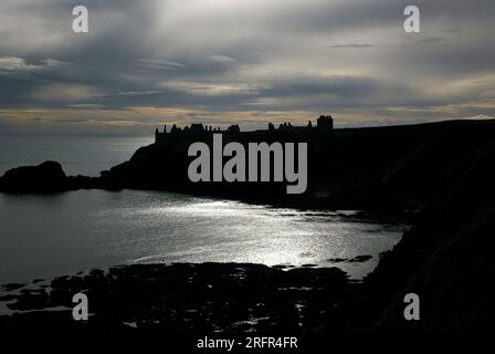 Colour photograph of Dunnottar Castle in silhouette and dramtic clouds ...