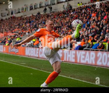 Shayne Lavery of Blackpool controls the ball under pressure from Nathan ...