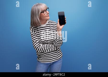 middle aged business woman surfs the internet using smartphone on ...