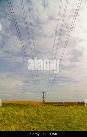Line of electric pylons into distance above countryside, landscape ...