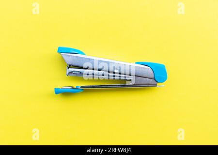 Office stapler with staples on yellow background Stock Photo - Alamy