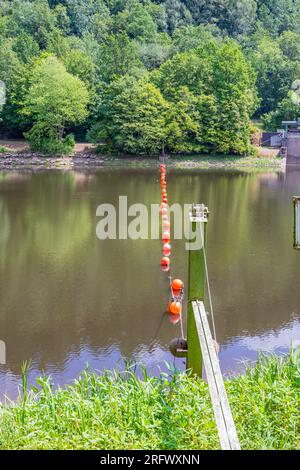Orange buoys crossing river Prum in Stausee Bitburg reservoir with ...