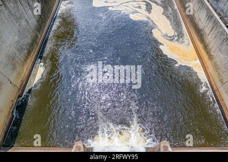 Water flowing from Staumauer Bitburger dam into Prum river, valley and ...