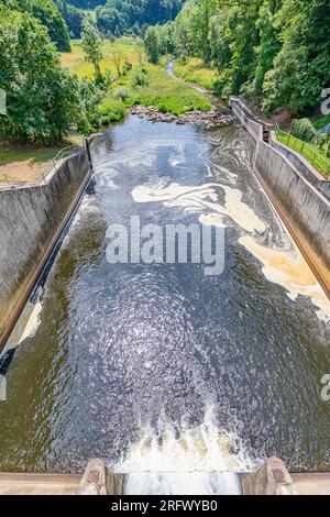 Gate of Staumauer Bitburger dam with water flowing out into Prum river ...