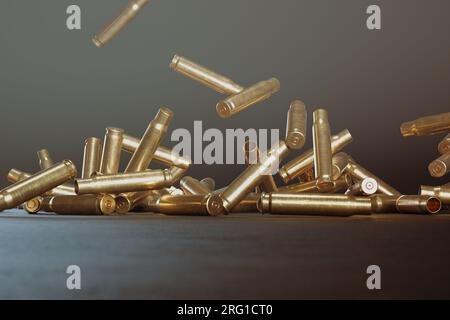An Empty shells falling on the floor. Open fire. Gun ammunition on dark ...