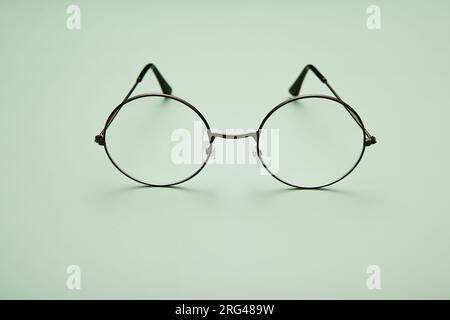 Open metal rimmed spectacles isolated on light-green Stock Photo - Alamy