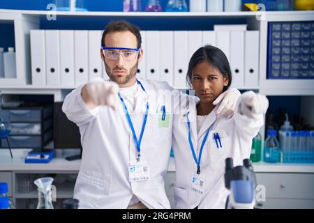 Interracial couple working at scientist laboratory smiling happy and ...