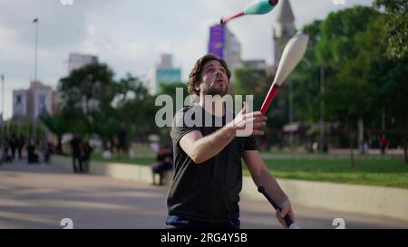 Male Juggler performer demonstrating his skills outside in urban city ...