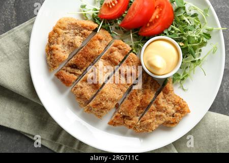 Delicious cut schnitzel served with microgreens on grey table Stock ...