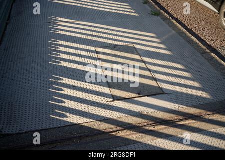 railings and shadows on the pavement Stock Photo - Alamy