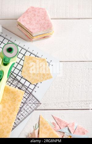 Fabric pentagon on craft mat next stack of pentagon pieces of fabrics ...