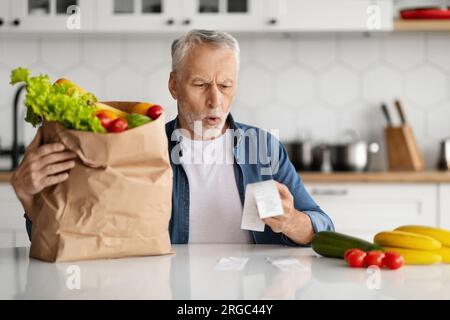 Shocked Senior Man Checking Grocery Bills In Kitchen After Food ...