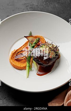 Slow-cooked beef cheek, charred shallots, asparagus spears, romesco ...
