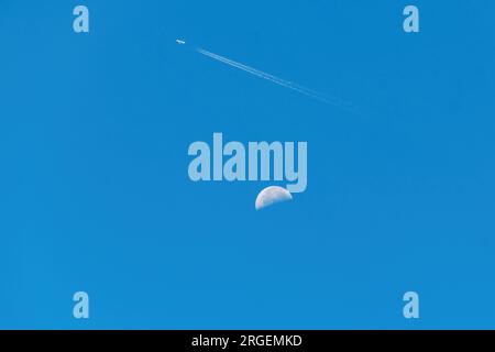 Daily Moon phase with plane in the blue sky Stock Photo - Alamy