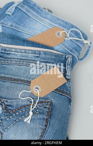 Stack of blue jeans and empty tags on white background Stock Photo - Alamy