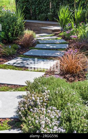 Path with large stone slabs through a garden, vertical Stock Photo - Alamy